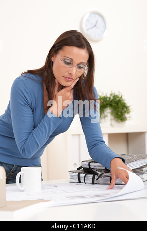 Attractive young brunette woman having a healthy breakfast reading a ...