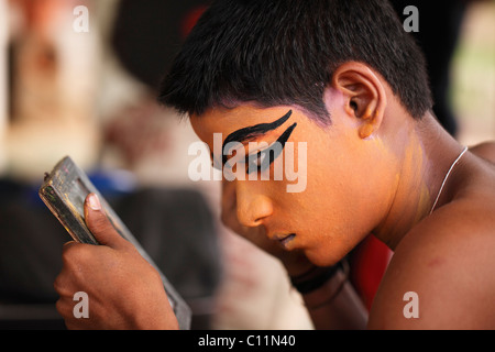 Kathakali dancer doing his make up, Minukku character, Kerala, southern ...