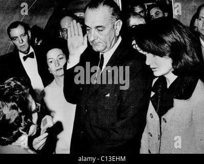 LYNDON B. JOHNSON is sworn in as US President aboard Air Force One on ...