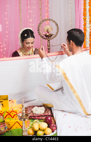 Bridegroom putting Mangal Sutra to a bride at the South Indian wedding ...