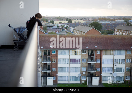 Boy looking over balcony on housing estate in East London Stock Photo ...