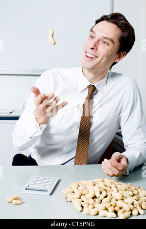 Businessman peanut and calculator Stock Photo - Alamy