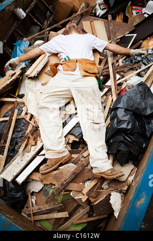 Man filling skip with rubble Stock Photo - Alamy