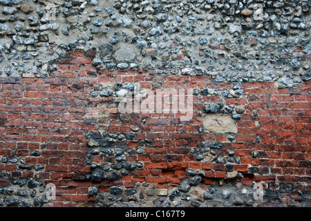 Detail of a flint and red brick wall, with circular patress wall tie ...