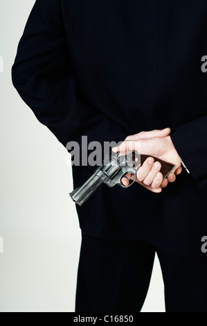 Man hiding gun behind his back Stock Photo - Alamy