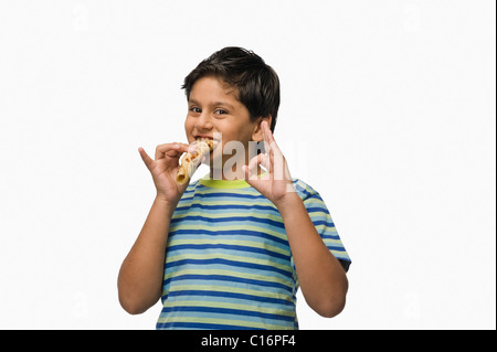Boy eating bread and showing ok sign Stock Photo - Alamy