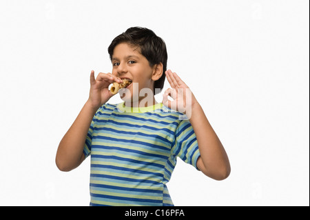 Boy eating bread and showing ok sign Stock Photo - Alamy