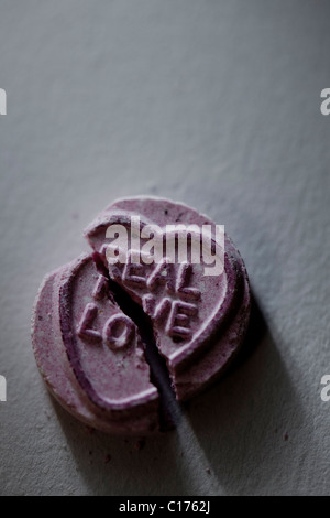 A broken love heart sweet with the message " Real Love Stock Photo - Alamy