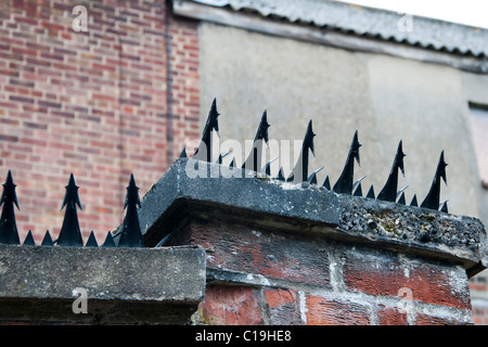 security spikes on top of Brick wall gate Stock Photo - Alamy