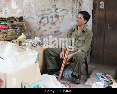 Vietnamese man smoking tobacco with traditional bamboo pipe, Old Quater ...