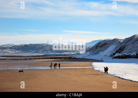 People walking on the beach at Benllech on the Isle of Anglesey. A blur ...