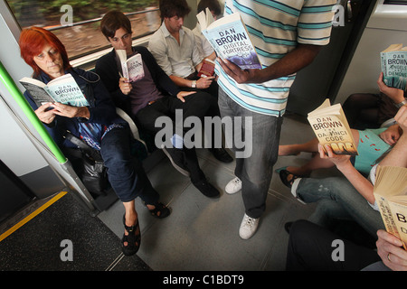 London Underground commuters, reading books, on a bury commuter route ...