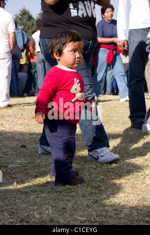 Small Mexican kid with a sad face wearing a red sweater Stock Photo - Alamy