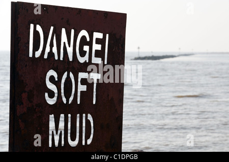 A sign warning of dangerous soft mud on the beach in Weston-super-Mare ...