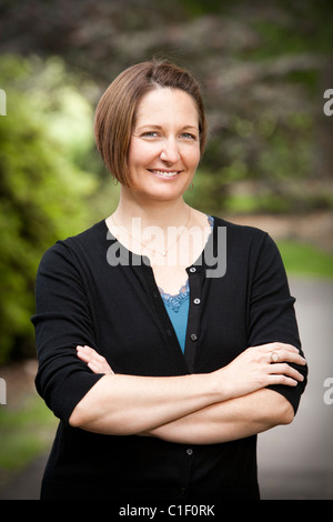 Happy young woman standing in interior of big clothing boutique and ...