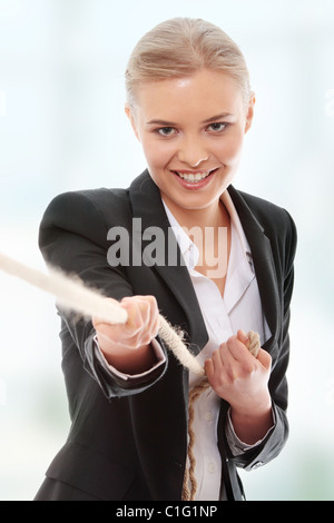 Businesswoman pulling on a piece of rope. Isolated on white Stock Photo ...