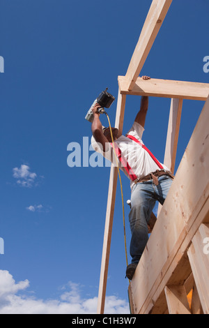 Low angle view of a carpenter nailing roof rafters Stock Photo - Alamy