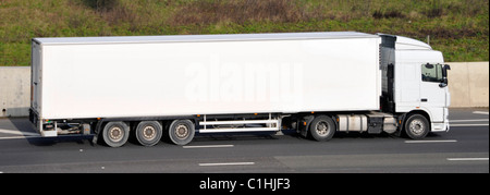 Transporting logistics by unmarked clean white hgv articulated lorry ...