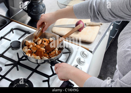 Adding spice to frying chicken Stock Photo - Alamy