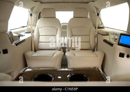 Luxury car interior limousine with black leather seats and a small bar ...