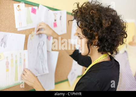 Hispanic young woman dressmaker designer using sewing machine shouting ...