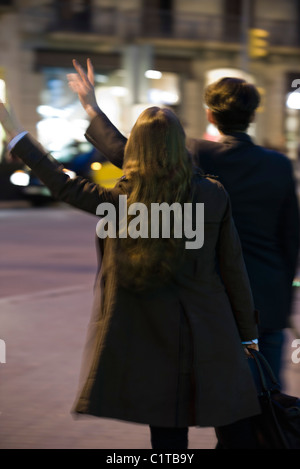 rear view of couple flagging down a bus Stock Photo - Alamy