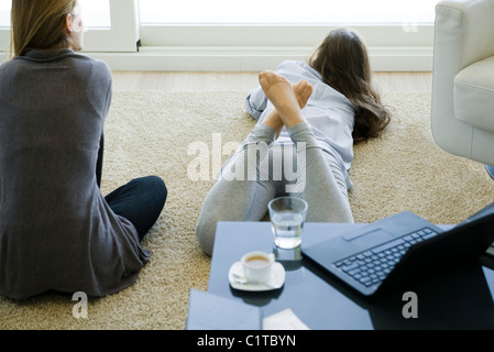 Two women hanging out at home party giving hight five while relaxing on ...