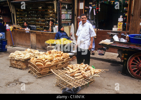 CAIRO, EGYPT. A man selling flatbread ('aish shamsi) from the bonnet of ...