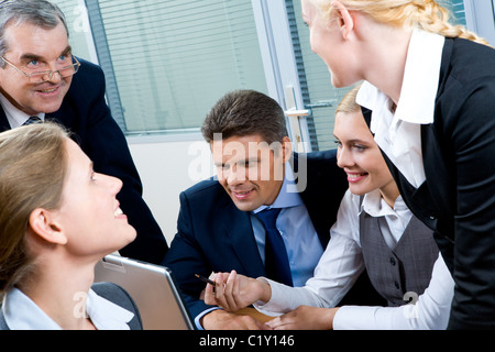 Portrait of confident co-workers interacting with each other at meeting ...