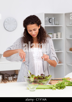 Young beautiful hispanic woman preparing vegetable smoothie with ...