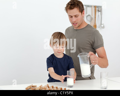 Handsome man giving milk to his son Stock Photo - Alamy