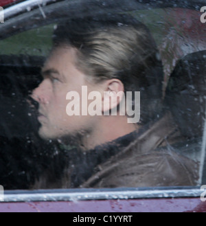 Leonardo DiCaprio driving a car in the rain while filming a scene for ...