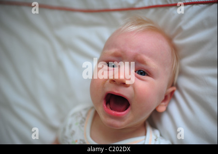 1 year old baby boy crying while sitting on the sofa Stock Photo - Alamy