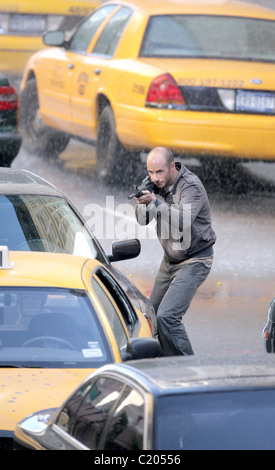 Actors stage a gun fight in the rain filming a scene for 'Inception ...