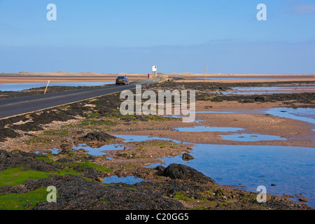 Vehicles crossing causeway to Holy Isle, Northumberland, England Stock ...