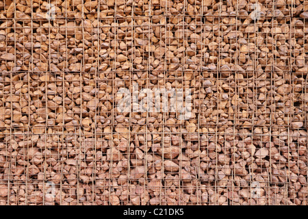 wire mesh and loose rock retaining wall with drain pipe perspective ...