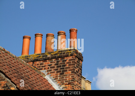 Brick chimney stack with terracotta chimney pots atop a traditional ...