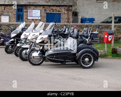 A row of touring motorcycles parked up on the cliff top of the coastal ...