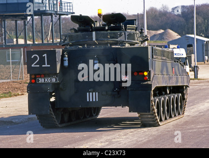 A Warrior armoured fighting vehicle crew prepare to camouflage their ...