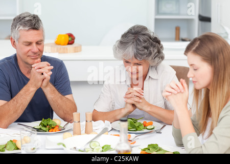 Young man praying at table in kitchen Stock Photo - Alamy