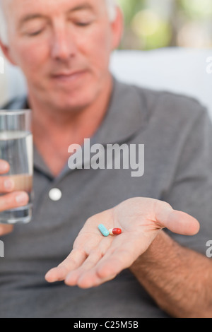 Retired man taking pills Stock Photo - Alamy