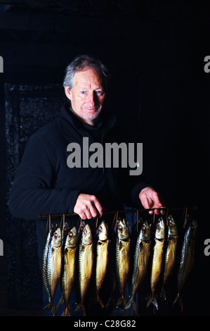 Bill Pinney holding smoked fish outside his smokehouse in Suffolk Stock ...