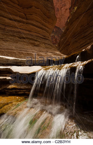 A waterfall flows over layers of desert rock Stock Photo - Alamy