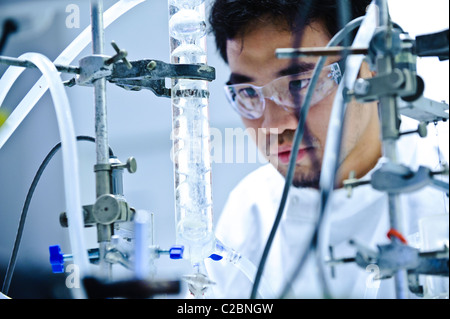 Young Asian male scientist wearing clear goggles and white science coat ...