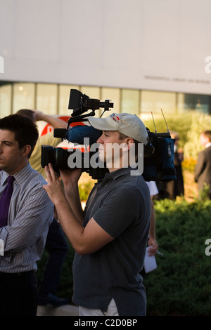 Nightly News Cameraman holding a video camera whilst a reporter ...