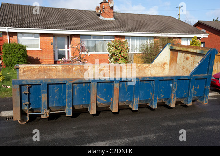 Builders waste rubbish skip, on pavement & yellow, line being filled ...