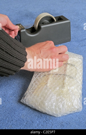 Close up of a man packaging tape roll adhesive tap Stock Photo - Alamy
