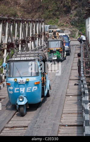 Pimped up tuk tuks travel over bridge in Kerala in the Rickshaw Run ...