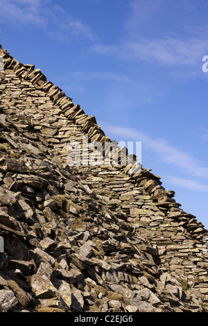 Old slate dry stone stone wall with archway over wooden gate into ...