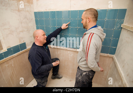 Teaching an apprentice wall tiling Stock Photo - Alamy